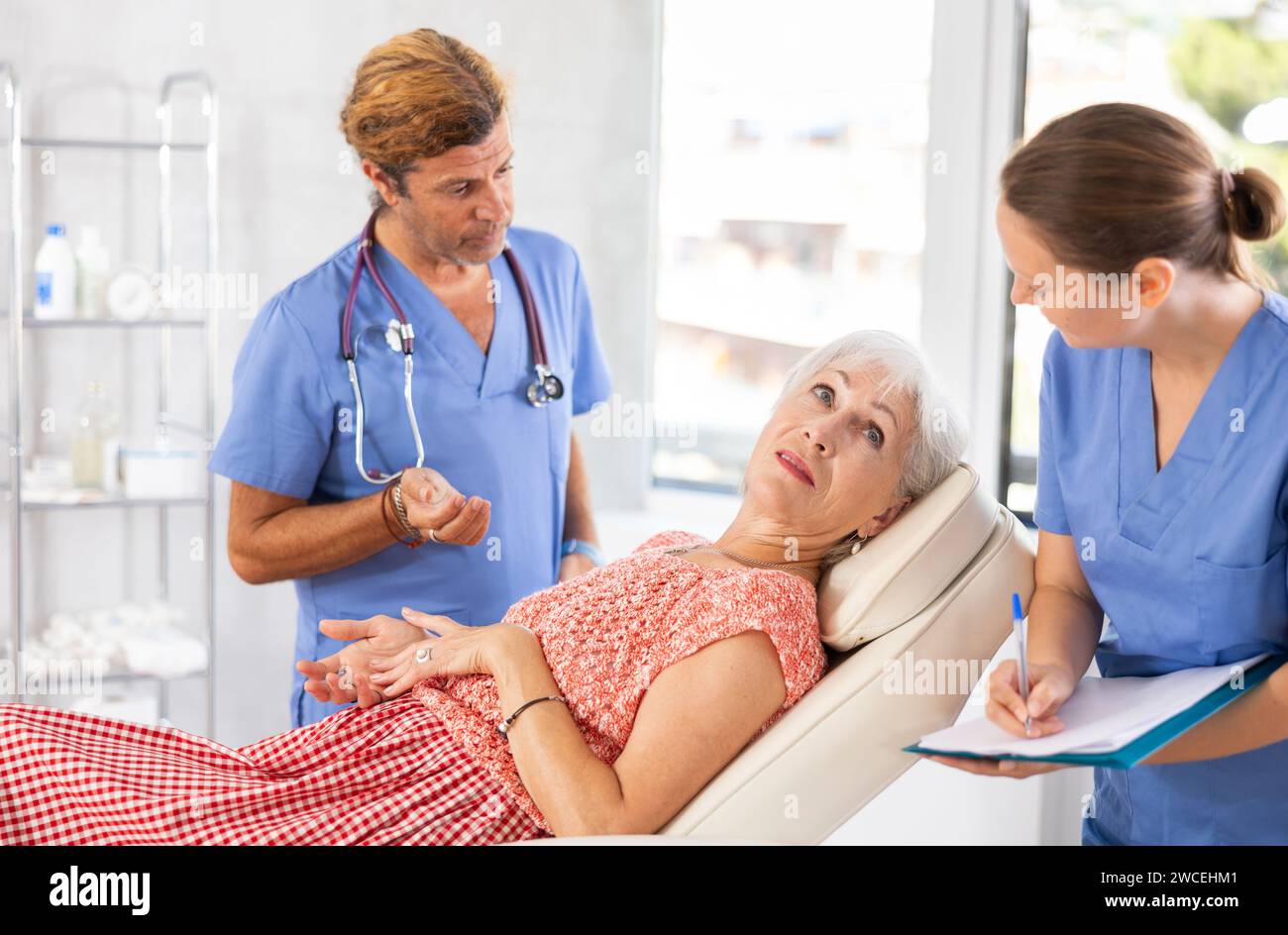 Female nurse and male doctor carries out survey of mature female ...