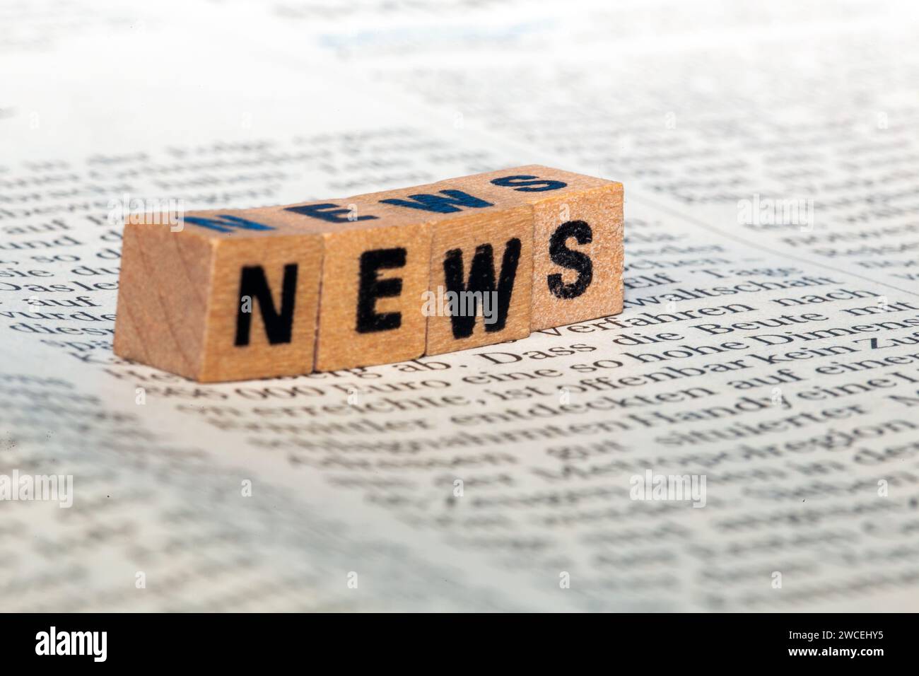 Symbol image NEWS: Letter cubes on a newspaper Stock Photo - Alamy