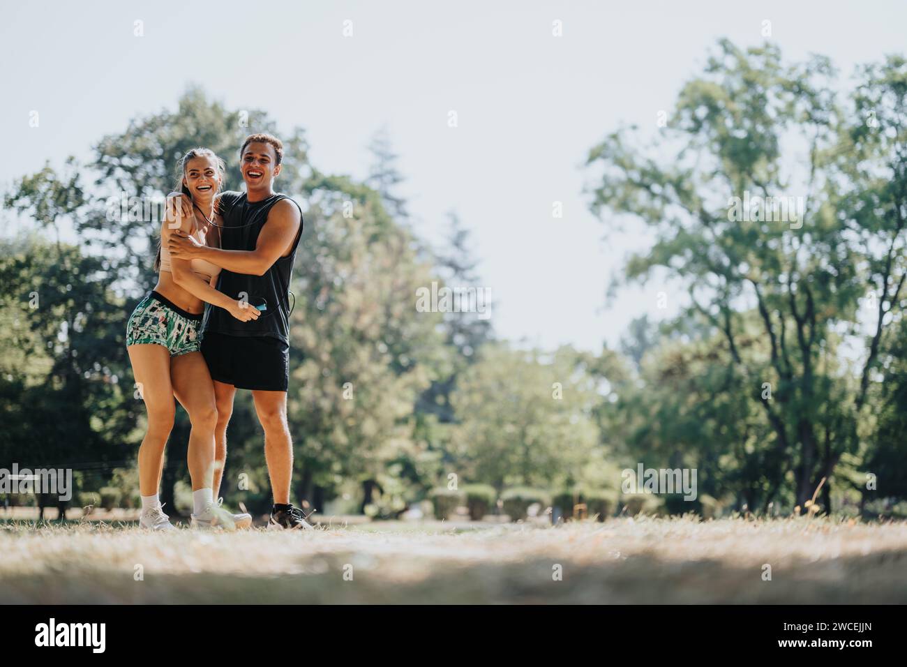 Caucasian couple jump ropes together in the park, showcasing their fit ...