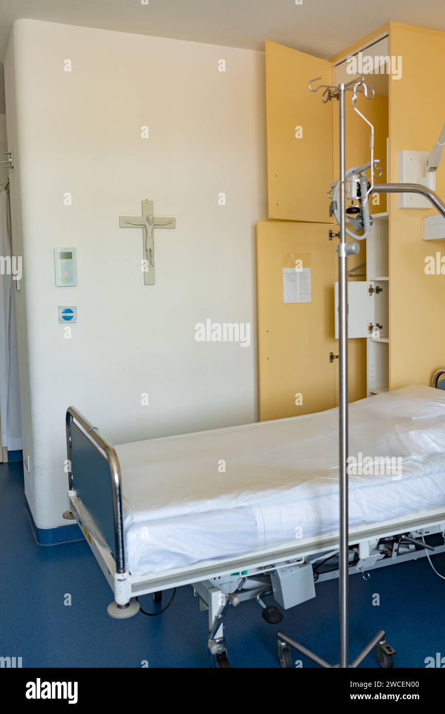 A religious cross is in the spotlight in a hospital ward. Medical ...
