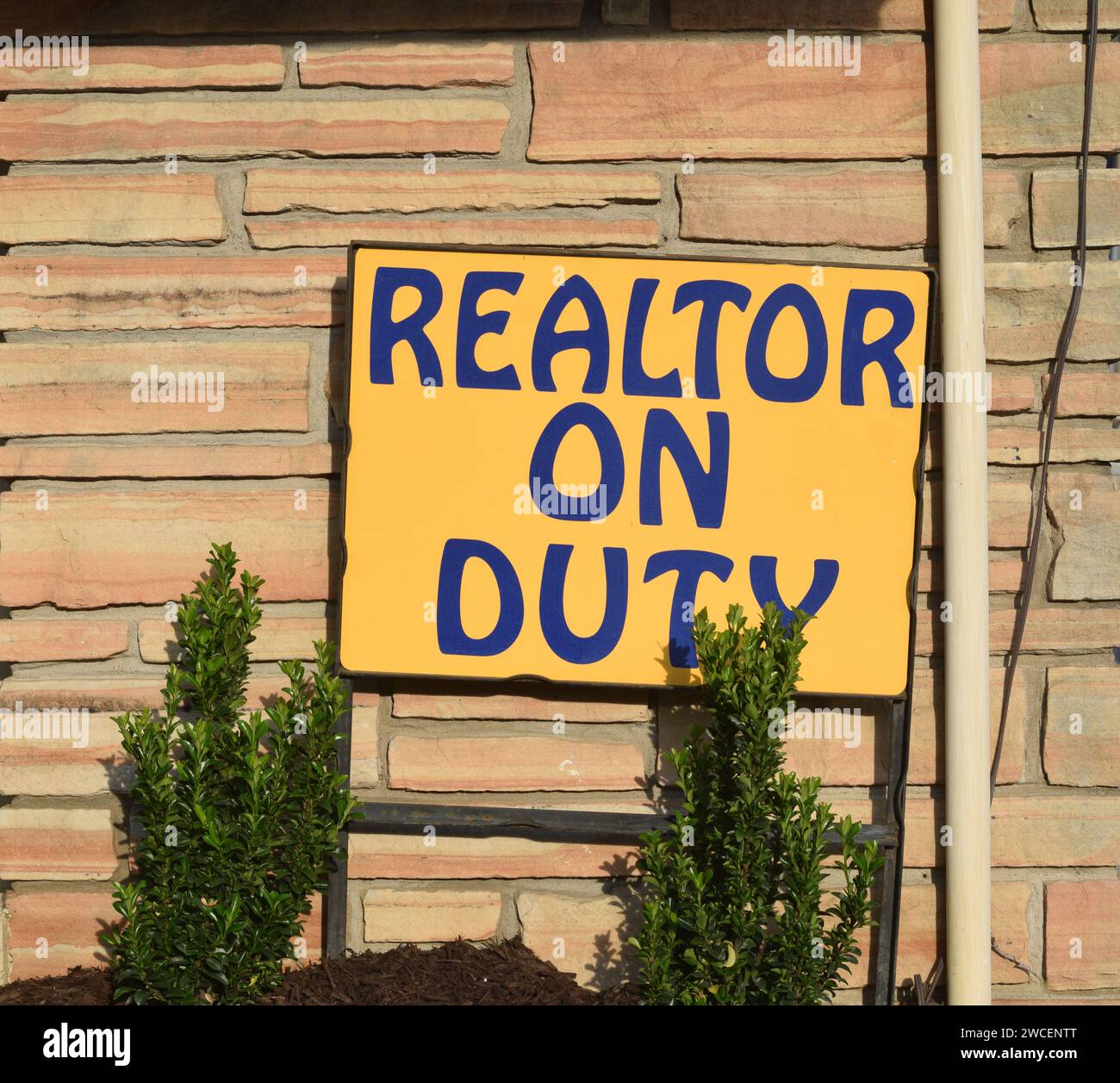 Yellow Realtor on Duty sign Stock Photo - Alamy