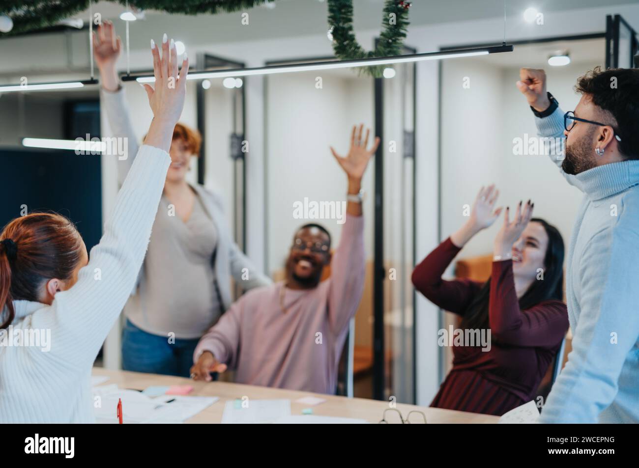 Multiracial teammates celebrate a big win together. Smiling and raising ...