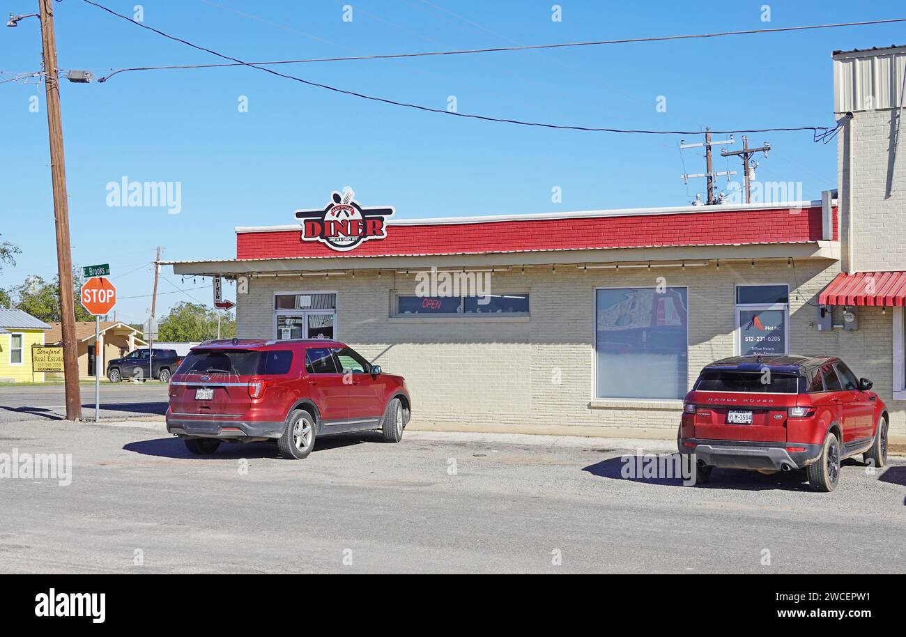 Two maroon SUVs parked in front of the Main Street Diner in Evant Texas ...