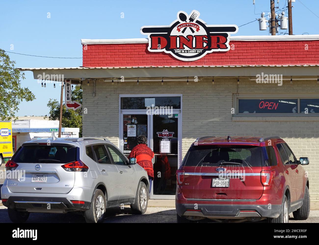 Two SUVs parked in front of the Main Street Diner in Evant Texas, a ...