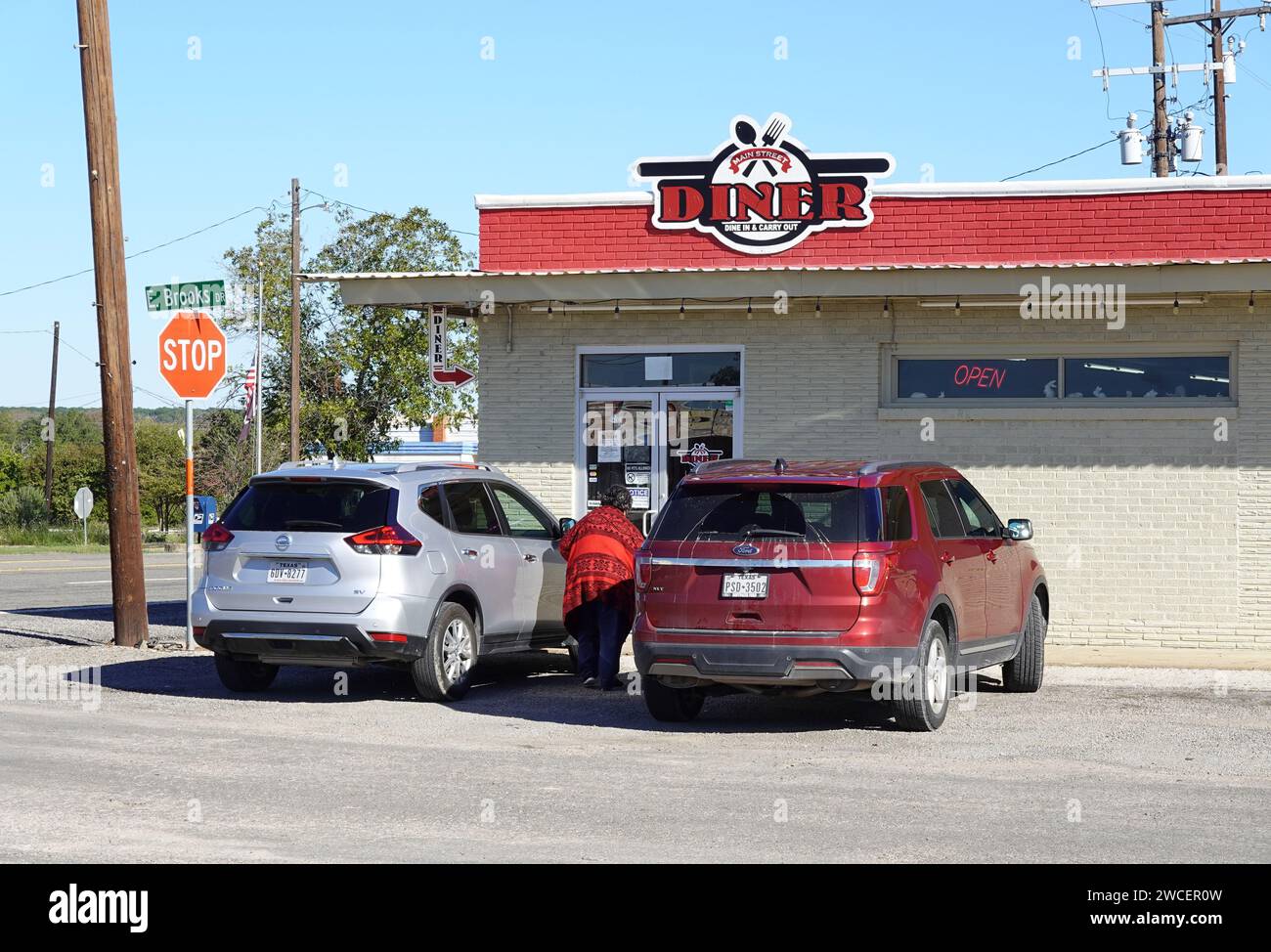 Two SUVs parked in front of the Main Street Diner in Evant Texas, a ...