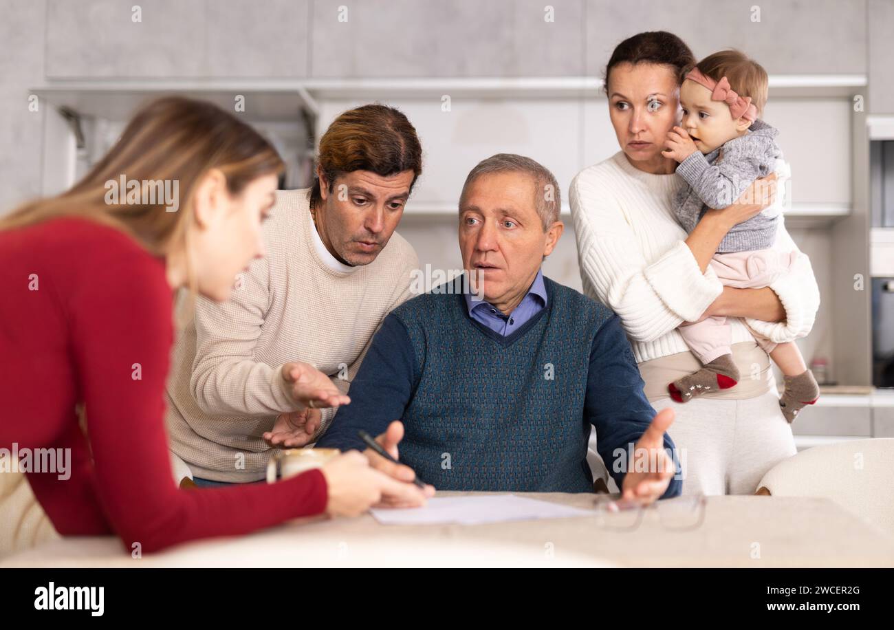 Family of different ages arguing while filling out important documents ...