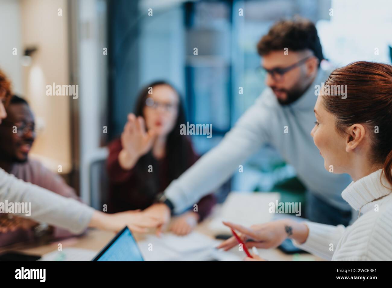 Group of businesspeople celebrating at office by putting hands together ...