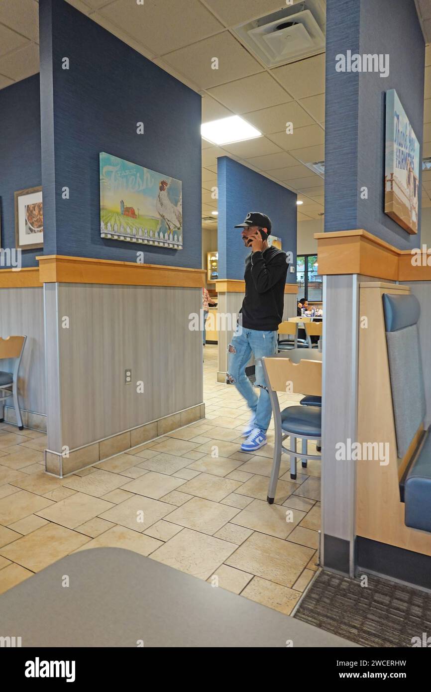 Gen Z young man talking on telephone inside a Culver's Restaurant ...