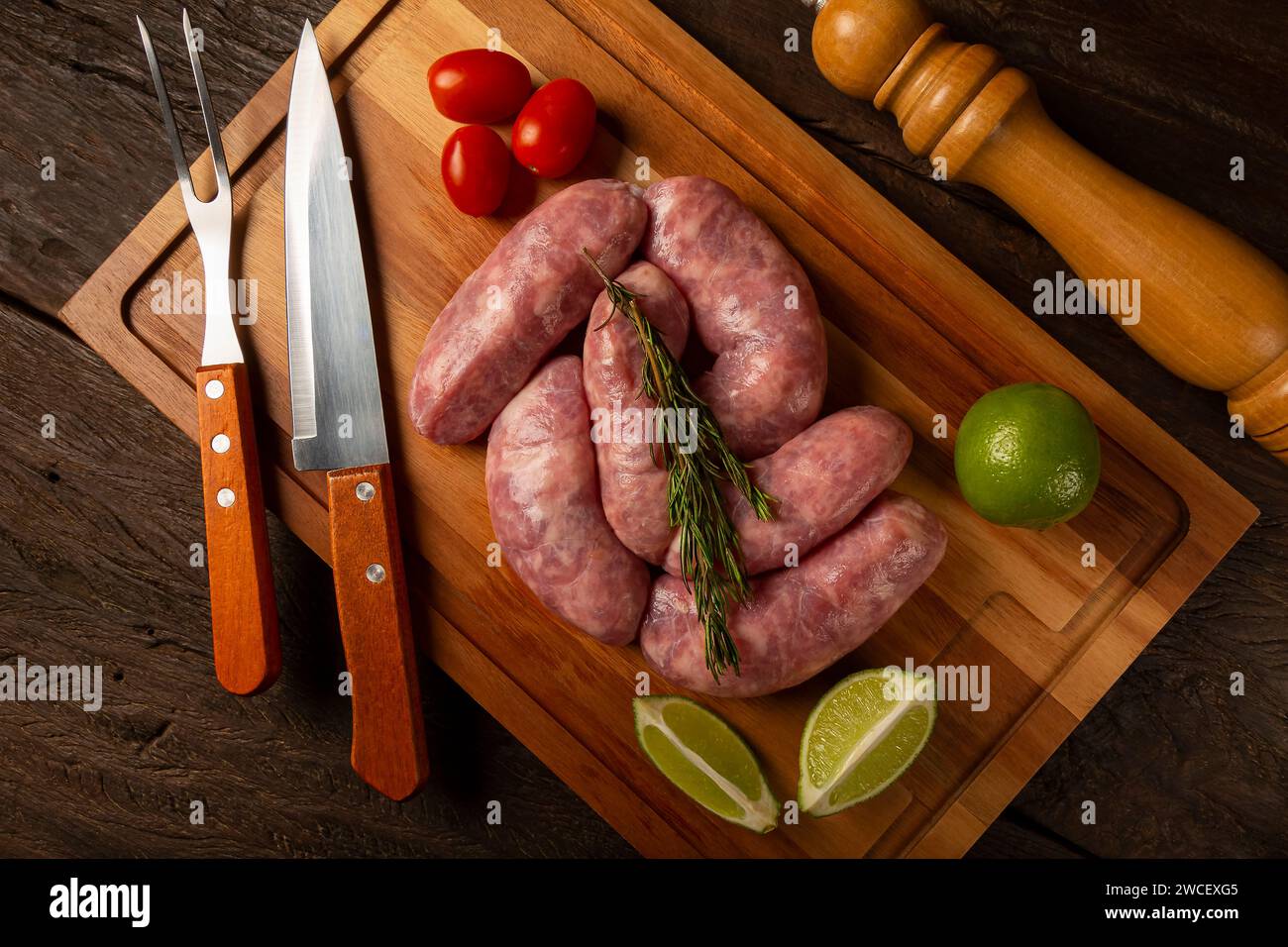 Raw barbecue sausages, ready to roast, on the wooden table Stock Photo ...