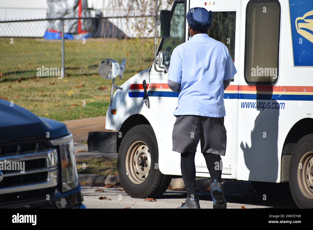 A United States Mailman walking toward his mail truck on a sunny day ...