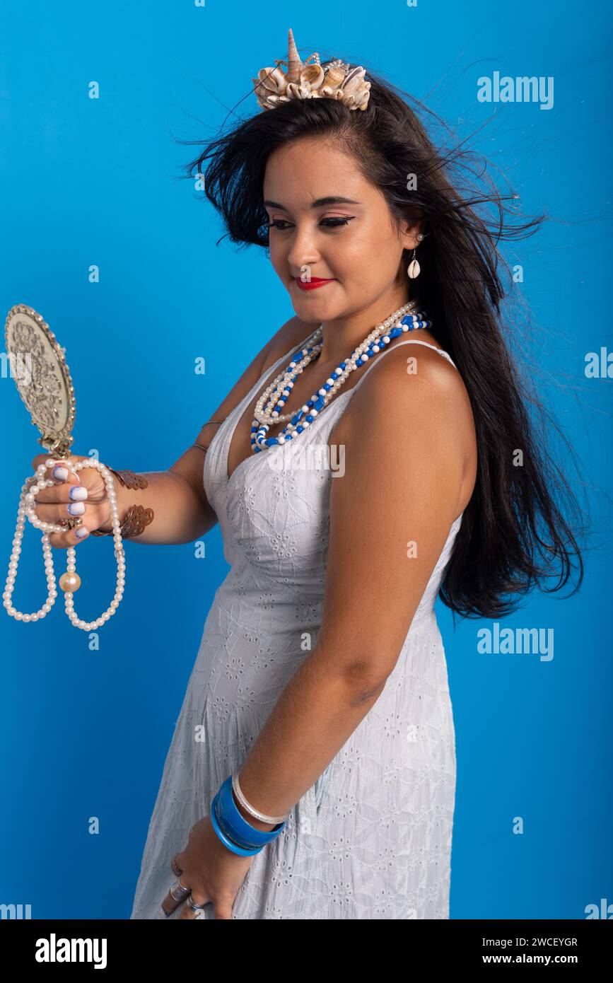 Portrait of beautiful black-haired woman wearing white outfit, holding ...