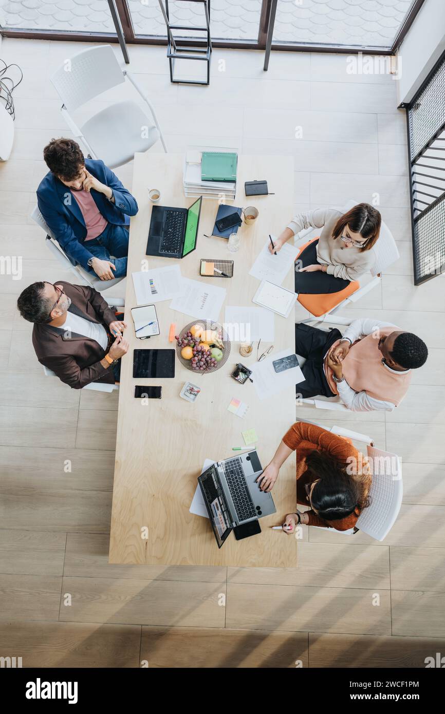 A multiethnic group of executives using technology and teamwork working ...