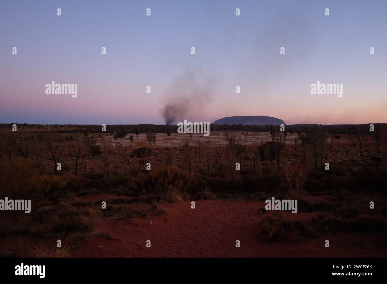 Drifts of grassfire smoke &Uluru at dusk with the Field of Light art ...