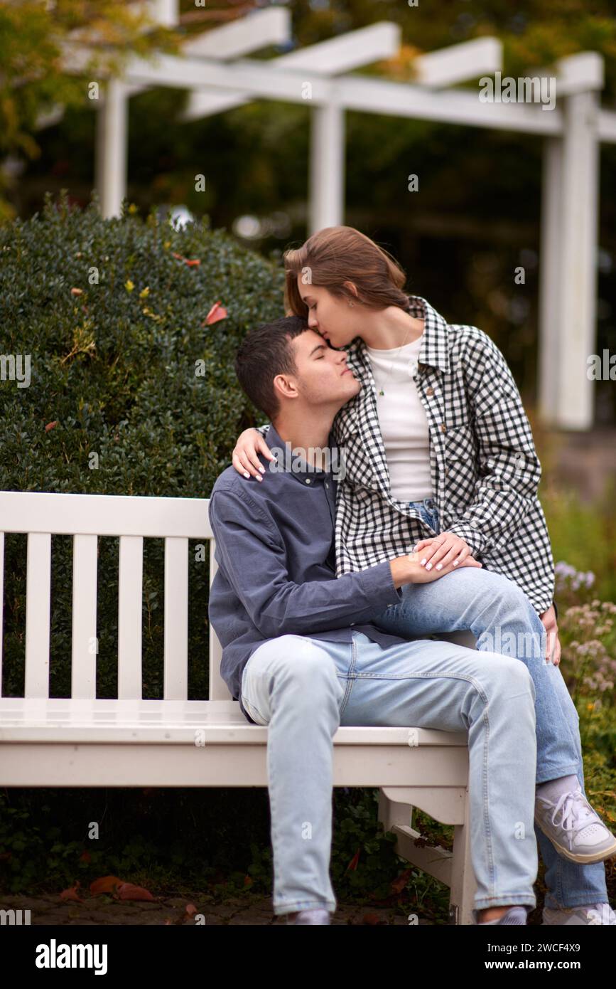 Autumn Romance: Young Couple Embracing and Kissing on Park Bench. Young ...