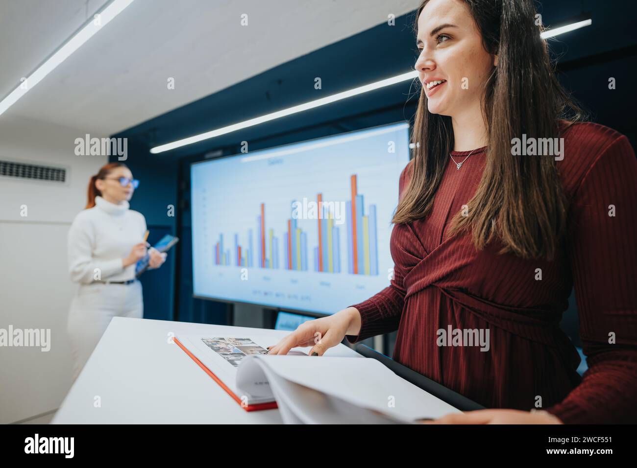 Business Group Attending A Lecture Collaborating And Analyzing Stats Together In A Classroom