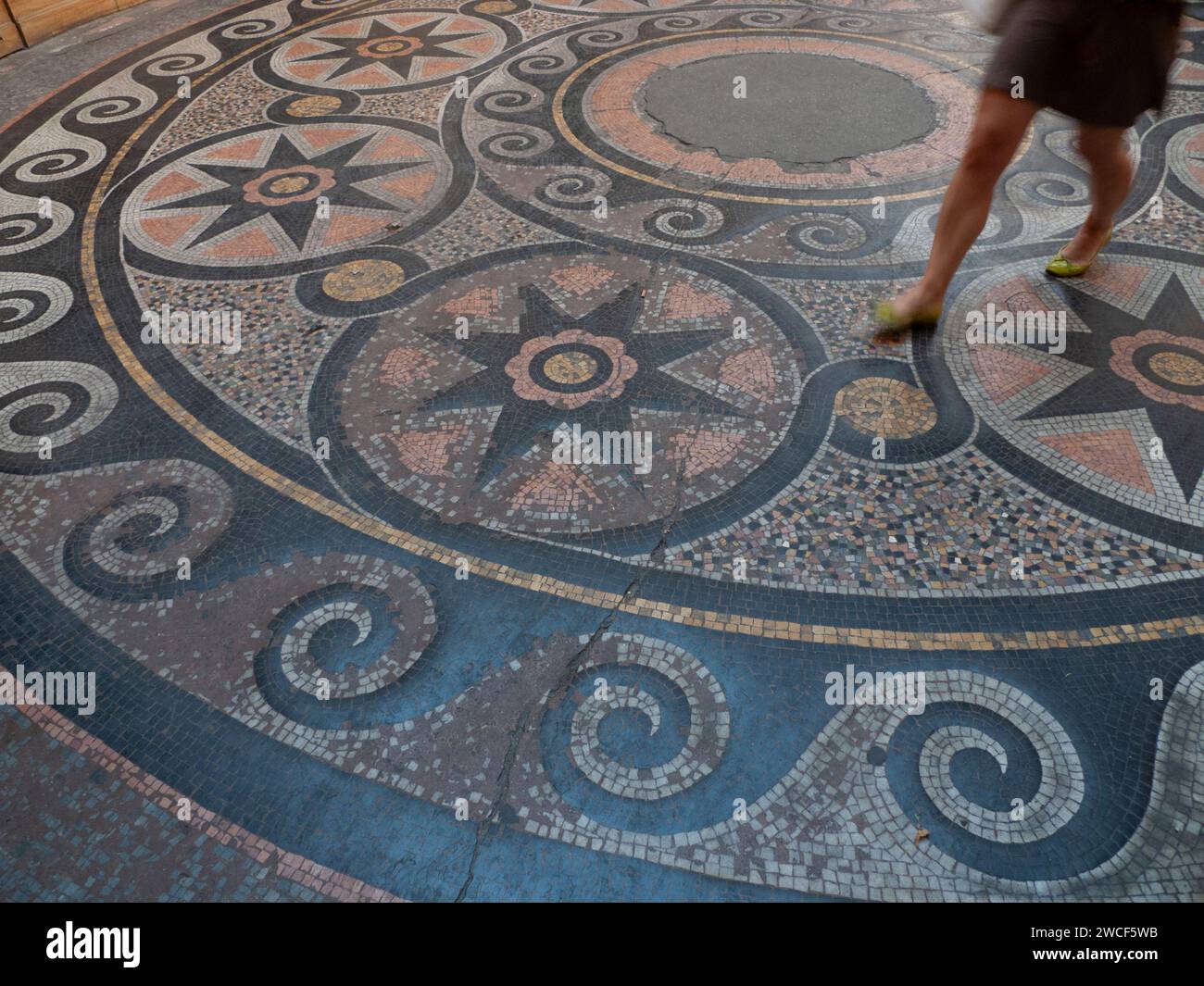 A fleeting moment captures the motion of a passerbys legs walking over ...