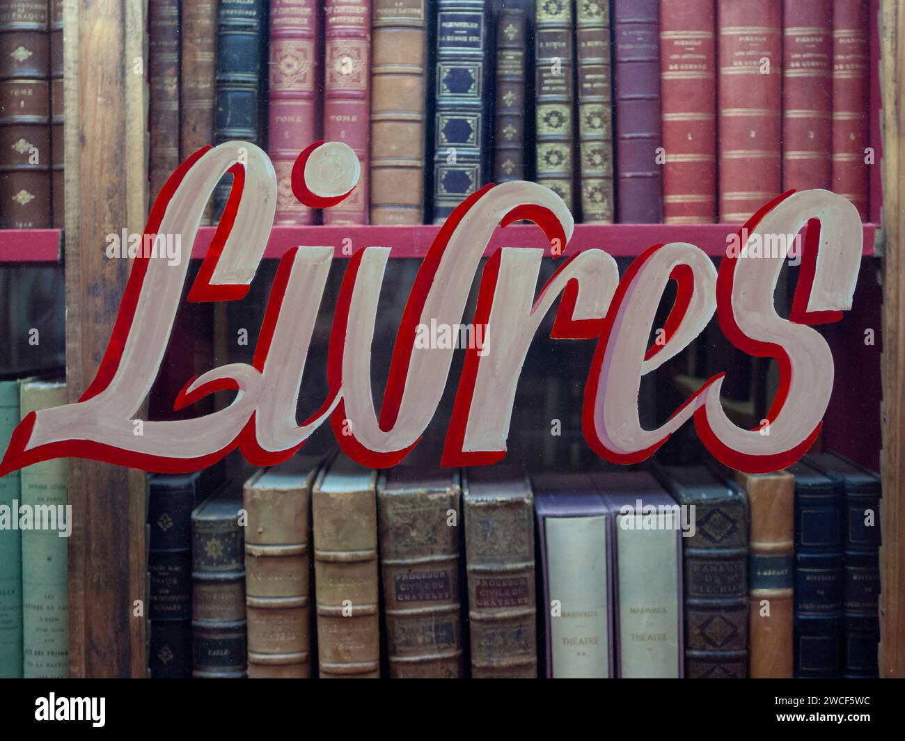 Vintage books on a shelf with 'Livres' sign, representing a library or ...