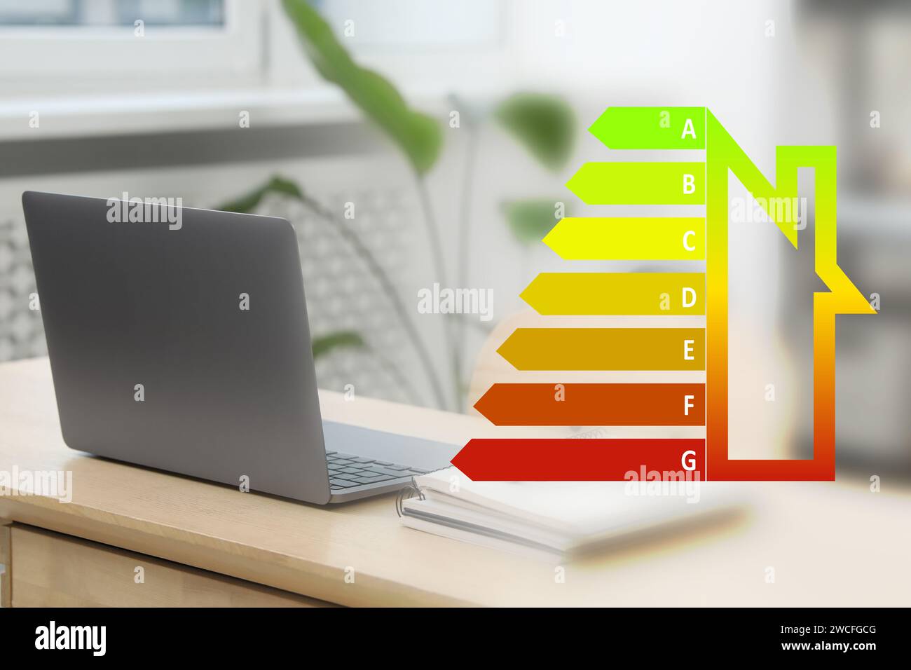 Energy efficiency rating and workplace. Wooden table with laptop ...