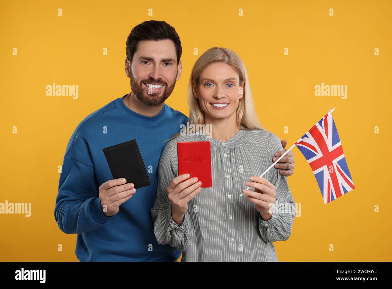 Immigration. Happy couple with passports and flag of United Kingdom on ...