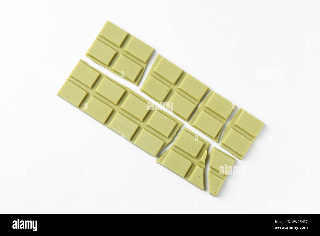 Pieces of tasty matcha chocolate bars on white background, top view ...