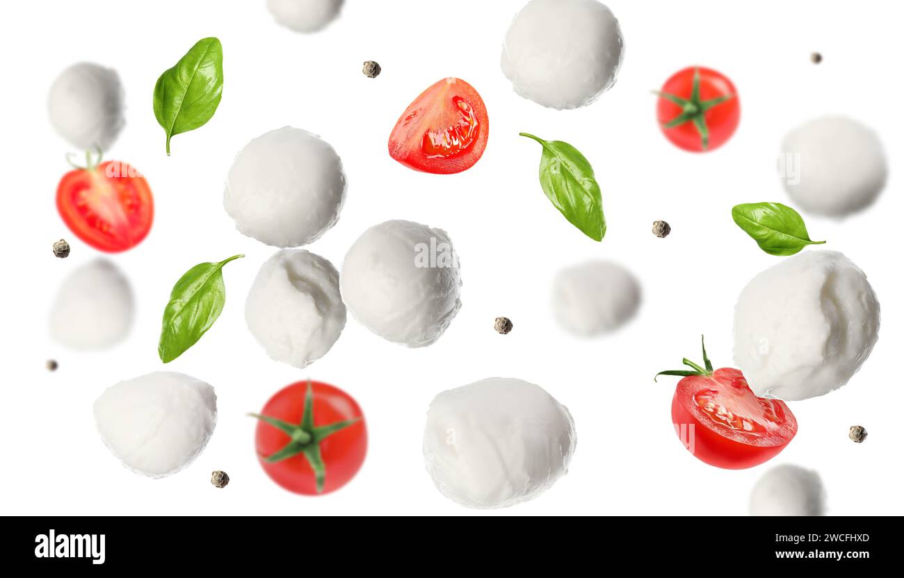 Mozzarella balls, tomatoes, basil leaves and peppercorns falling on ...