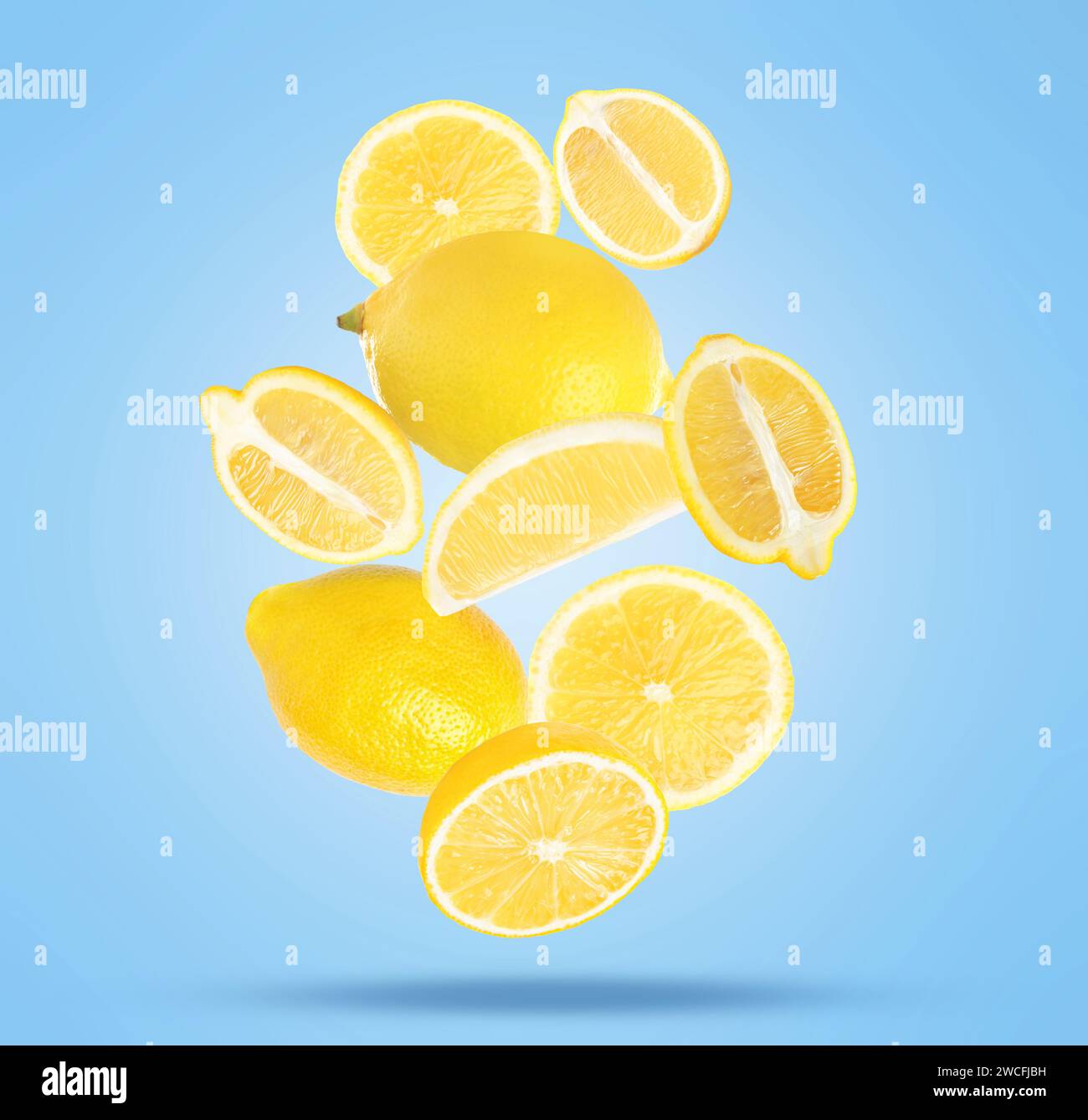 Fresh lemons falling on light blue background Stock Photo - Alamy