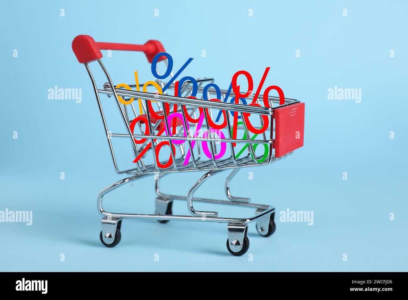 Discount offer. Mini shopping cart with percent signs on light blue ...