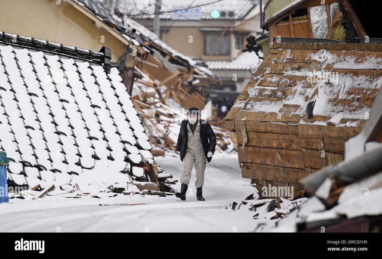 A man walks past a collapsed house in Wajima in central Japan's ...