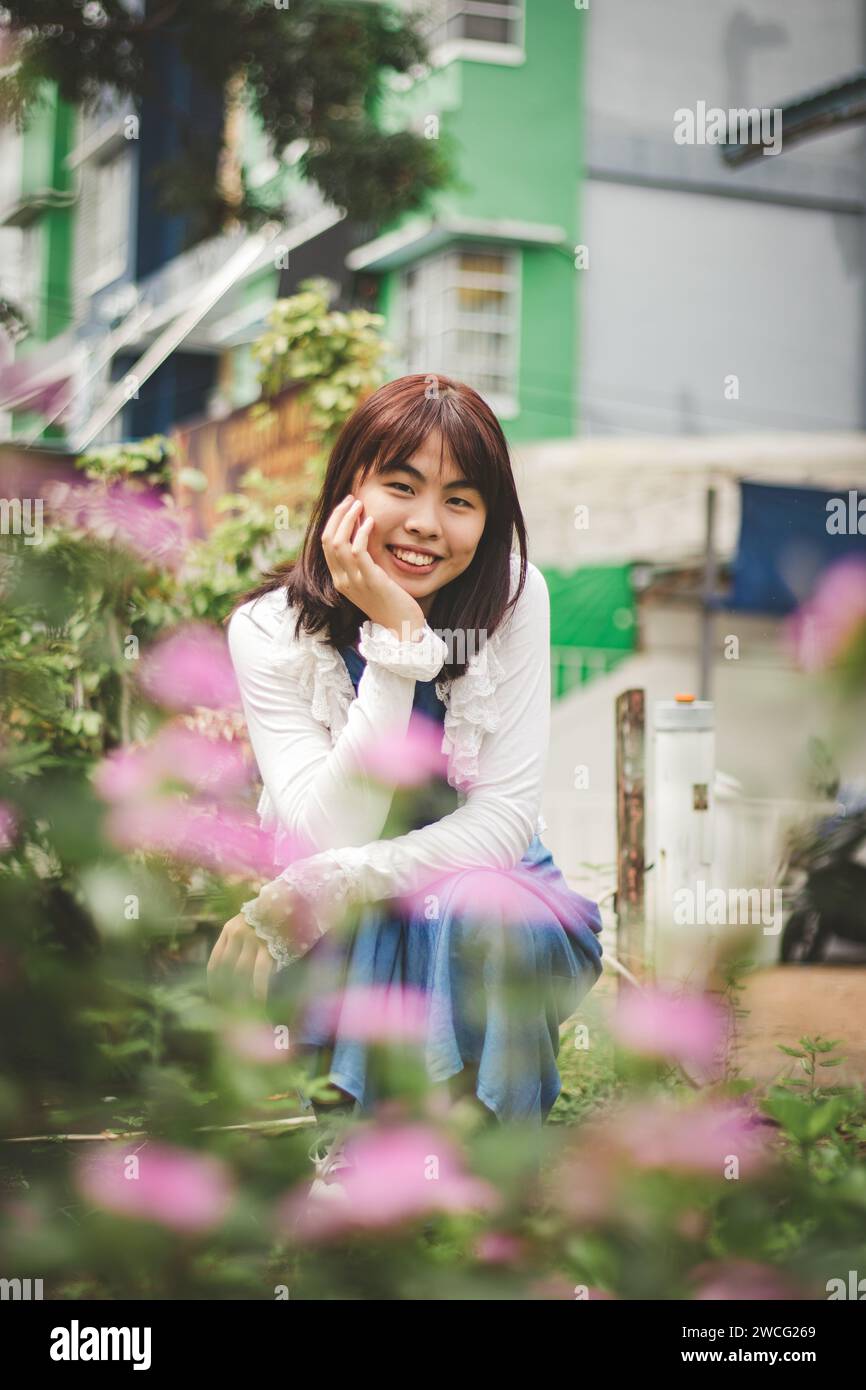 Young Beautiful Woman Planting flowers at the garden in Squatting Pose ...