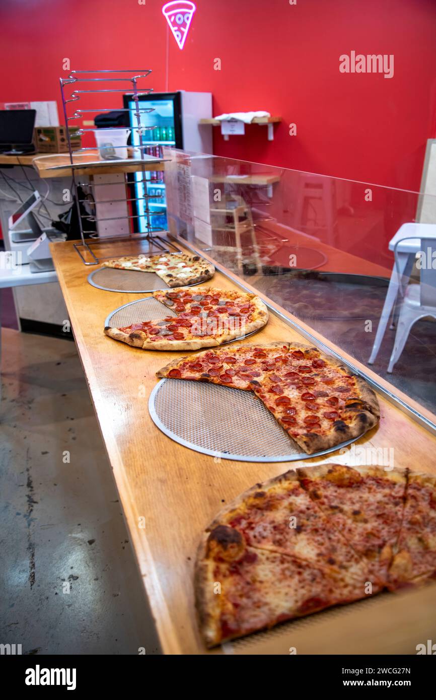 Lawrence, Kansas. Pizzas lined up on the counter in a pizza shop ...