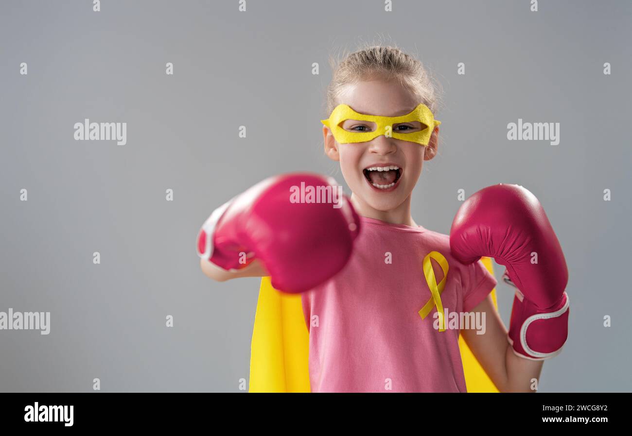 Child in boxing gloves with a yellow ribbon as a symbol of the fight ...