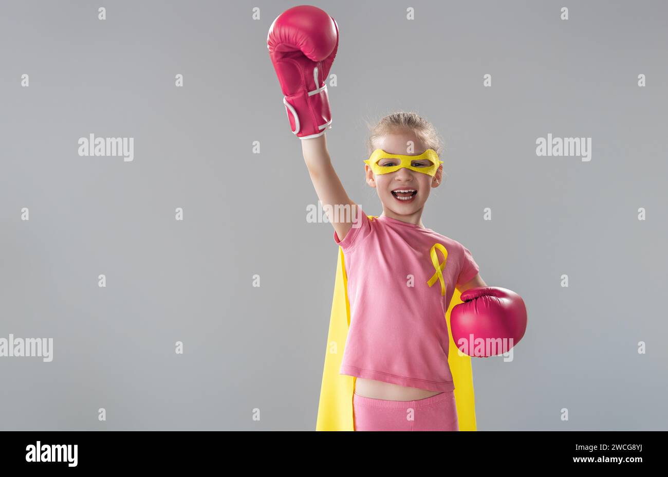 Child in boxing gloves with a yellow ribbon as a symbol of the fight ...