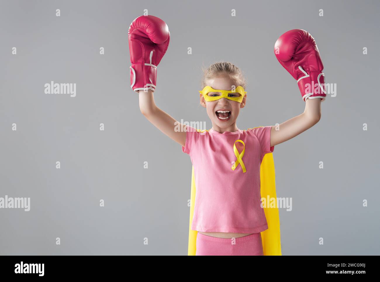 Child in boxing gloves with a yellow ribbon as a symbol of the fight ...