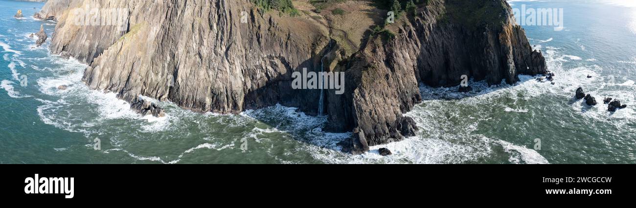 A narrow waterfall tumbles off an impressive cliff near the Neahkahnie ...