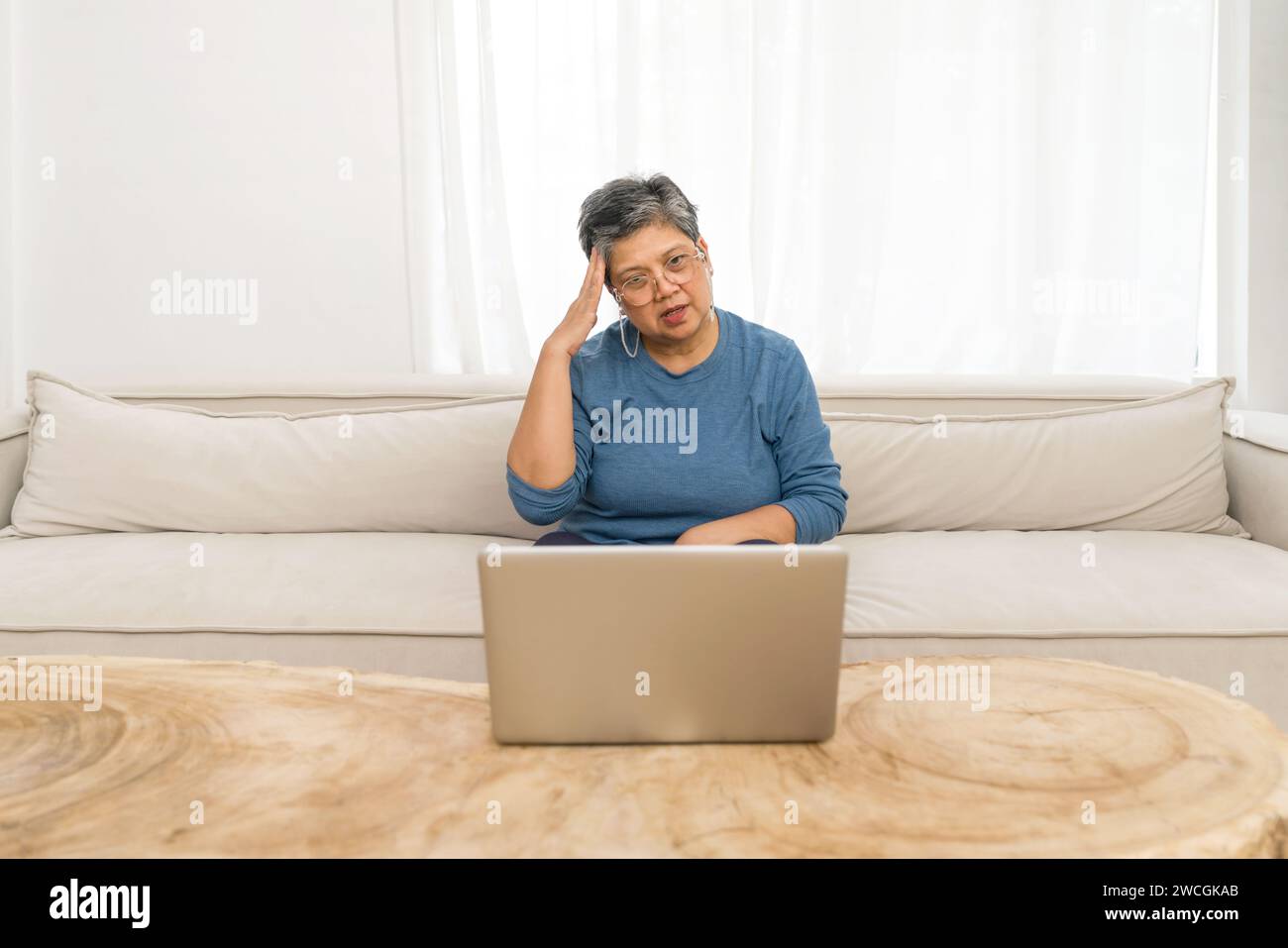 Asian gray hair old woman looking at laptop computer monitor, place her ...