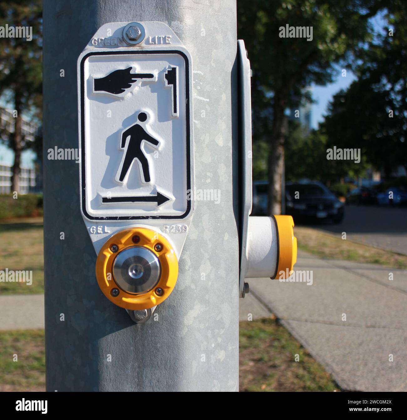 A yellow pedestrian crossing button on a pole Stock Photo - Alamy
