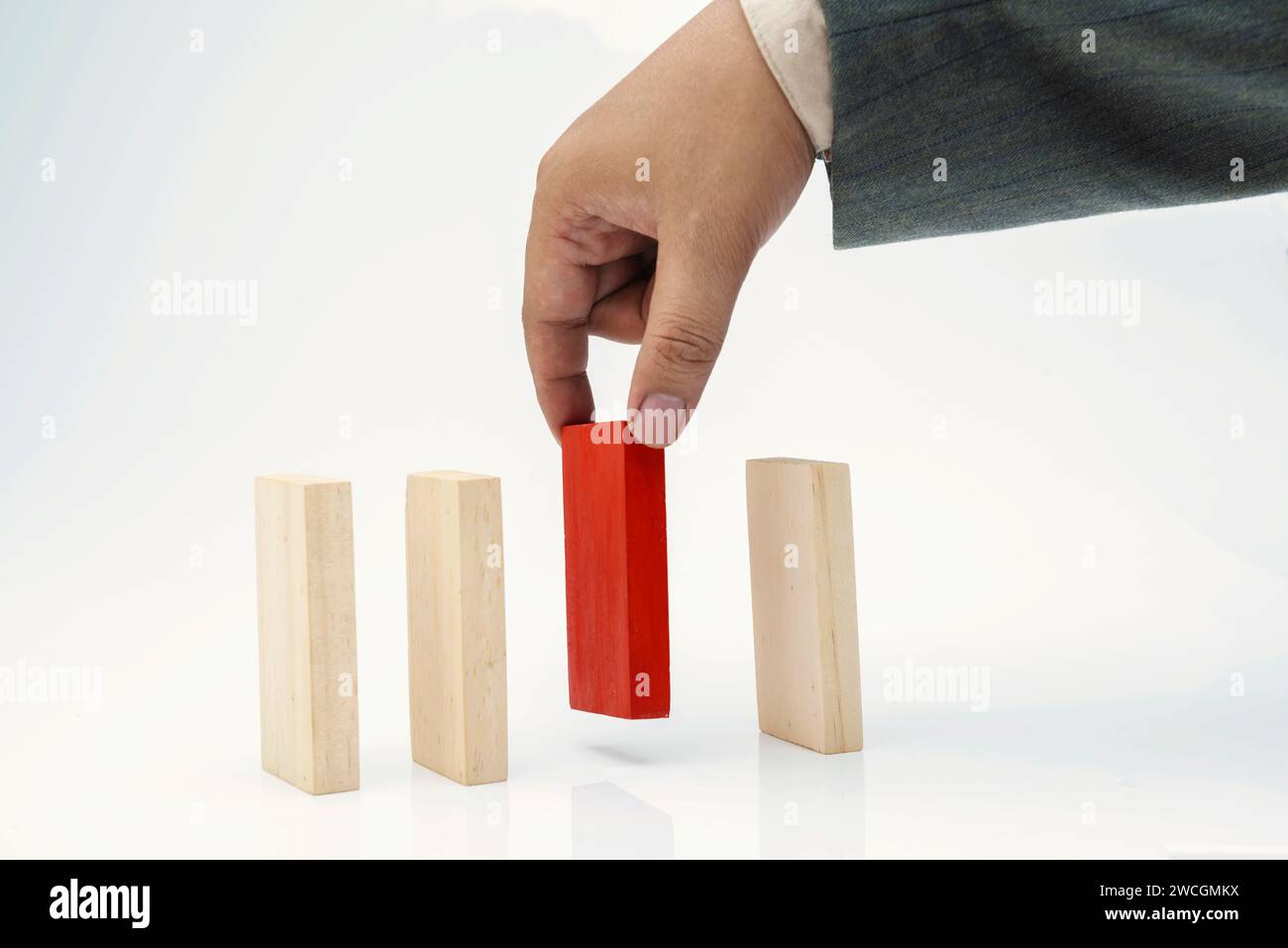Business hand put a red wooden block in a row of brown wooden blocks ...