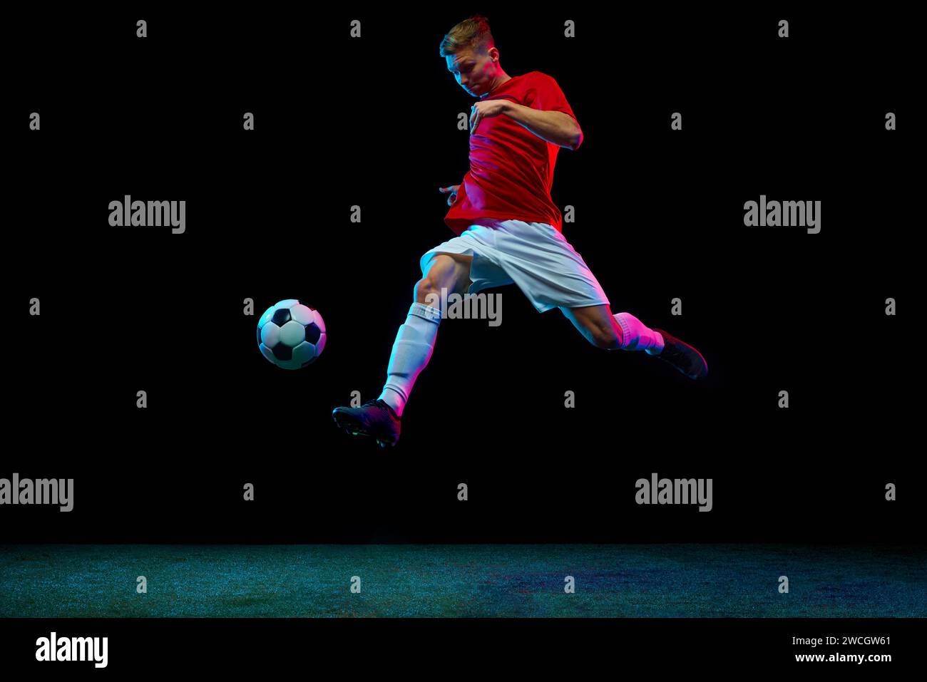 Perfect air kick. Professional soccer player sends ball soaring through ...
