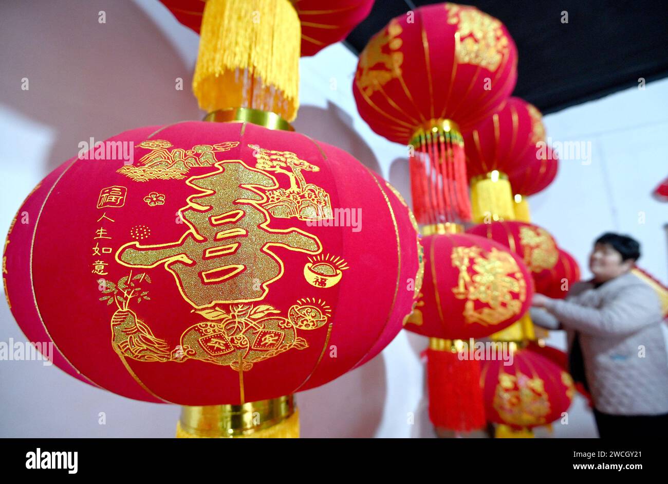 Handan, China. 16th Jan, 2024. A villager is arranging red lanterns ...