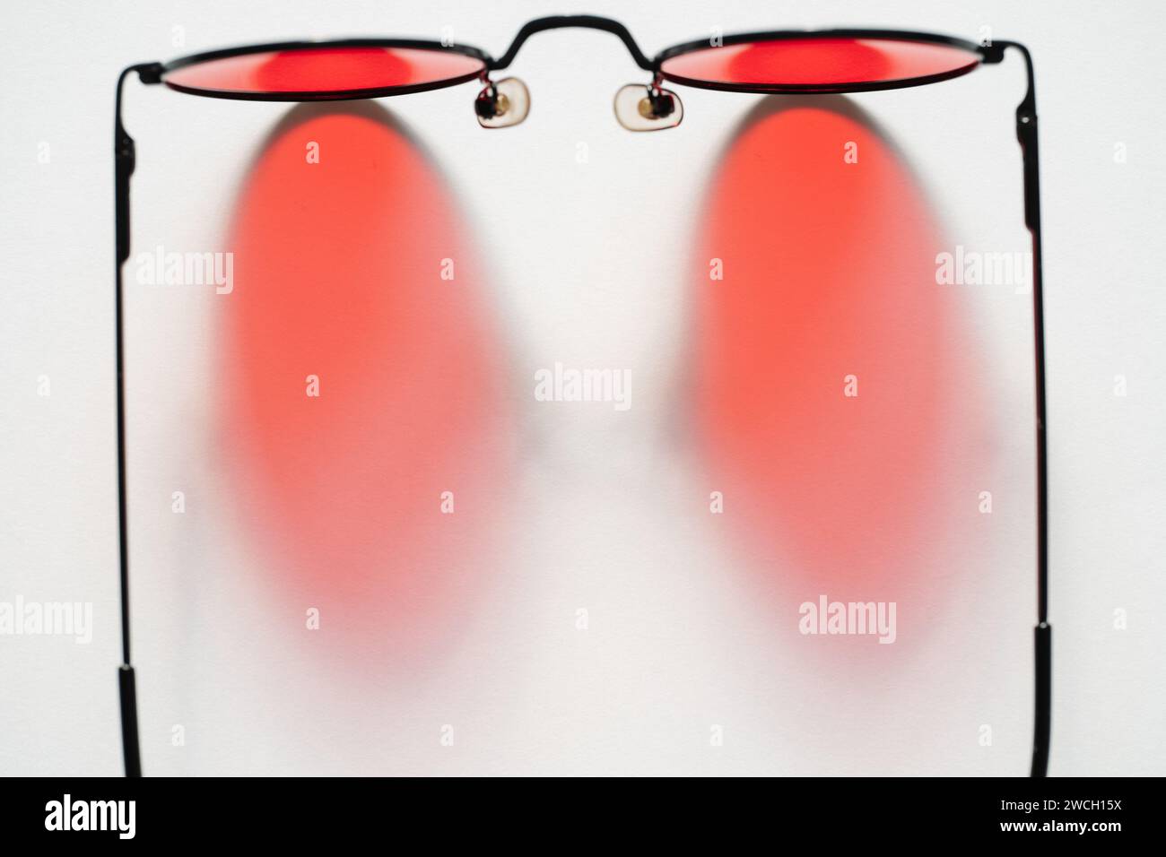 Red round sunglasses shadows on white background. Top view summer ...
