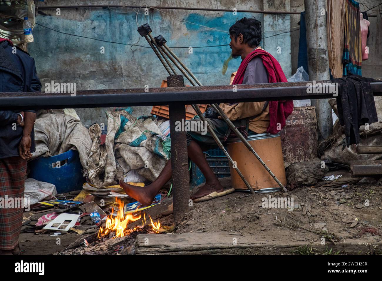 Amidst winter's chill, street people gather around a flickering fire ...