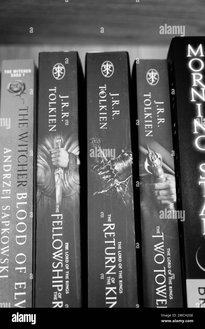 A collection of various books neatly arranged on a shelf, with one book ...