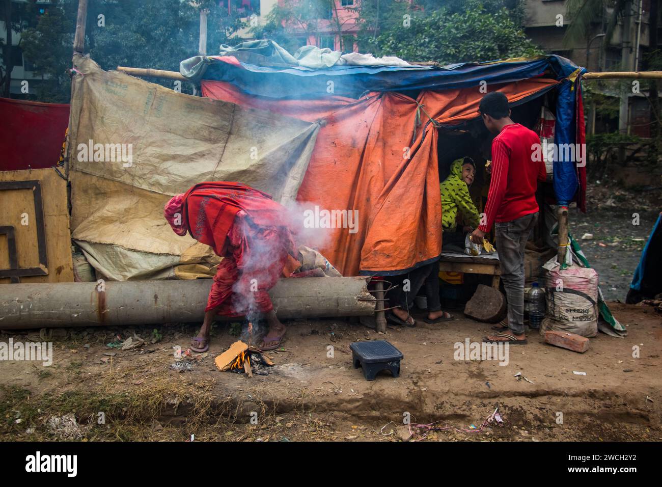 Amidst winter's chill, street people gather around a flickering fire ...