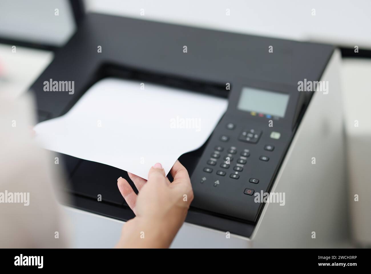 Person takes out white sheet from laser printer Stock Photo - Alamy