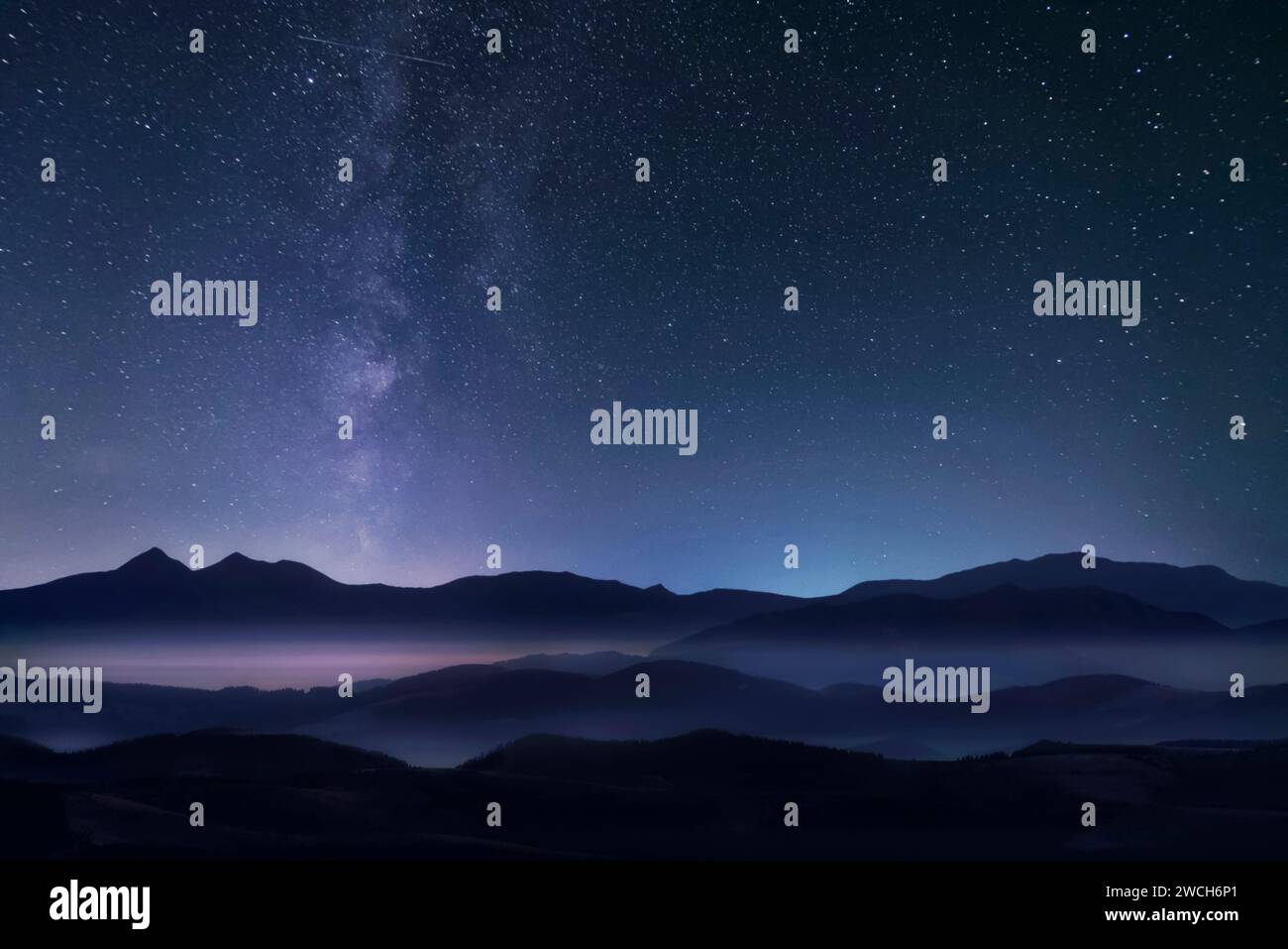 Starry night sky with milky way over the mountains Stock Photo - Alamy