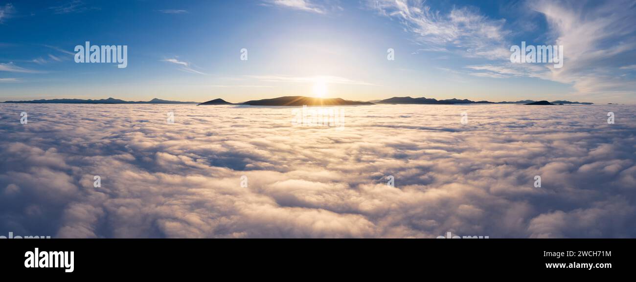 Landscape above the clouds with mountain peaks at sunrise. Dramatic ...