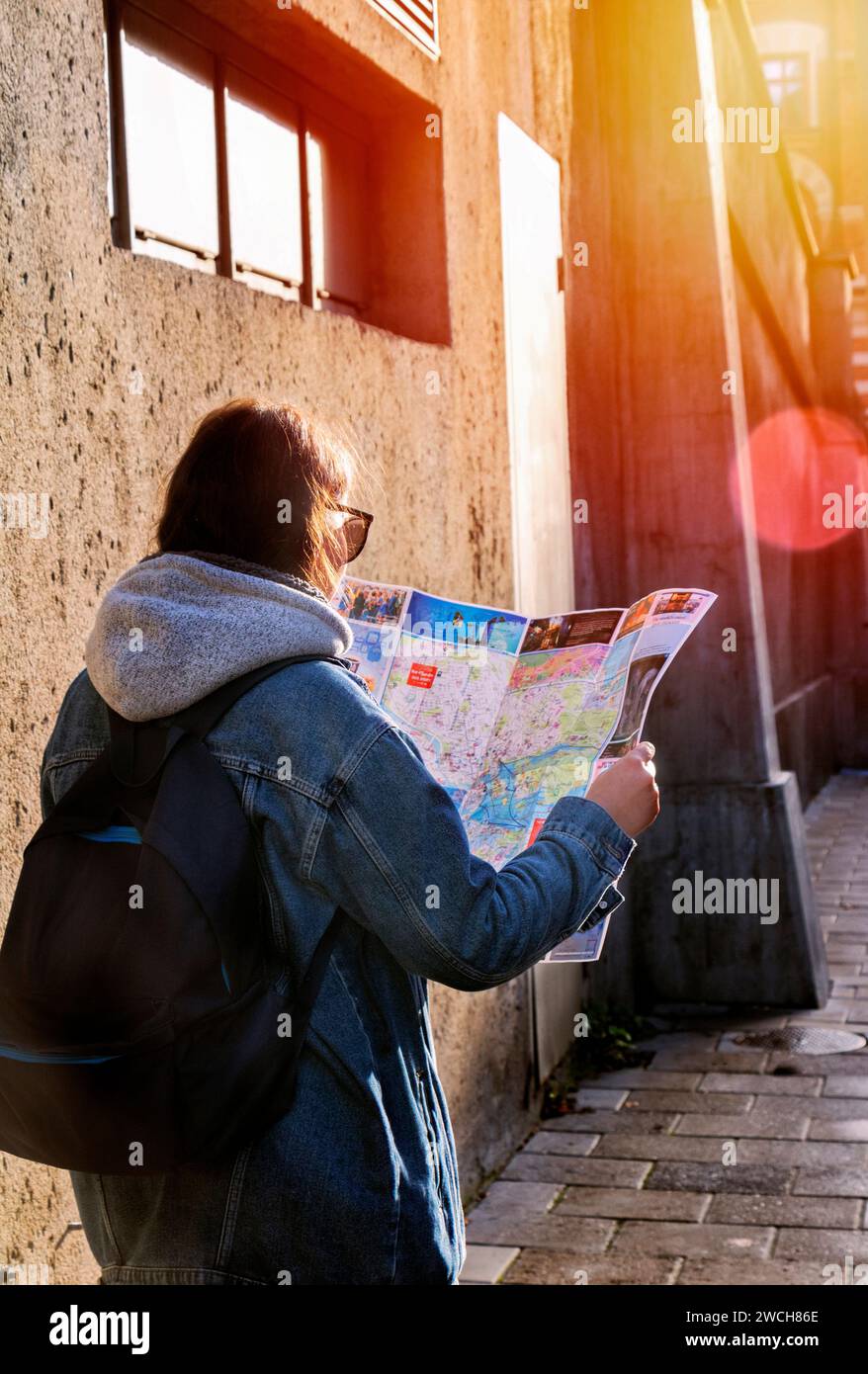 Beautiful woman get lost in city. Rear view of a traveler girl with ...