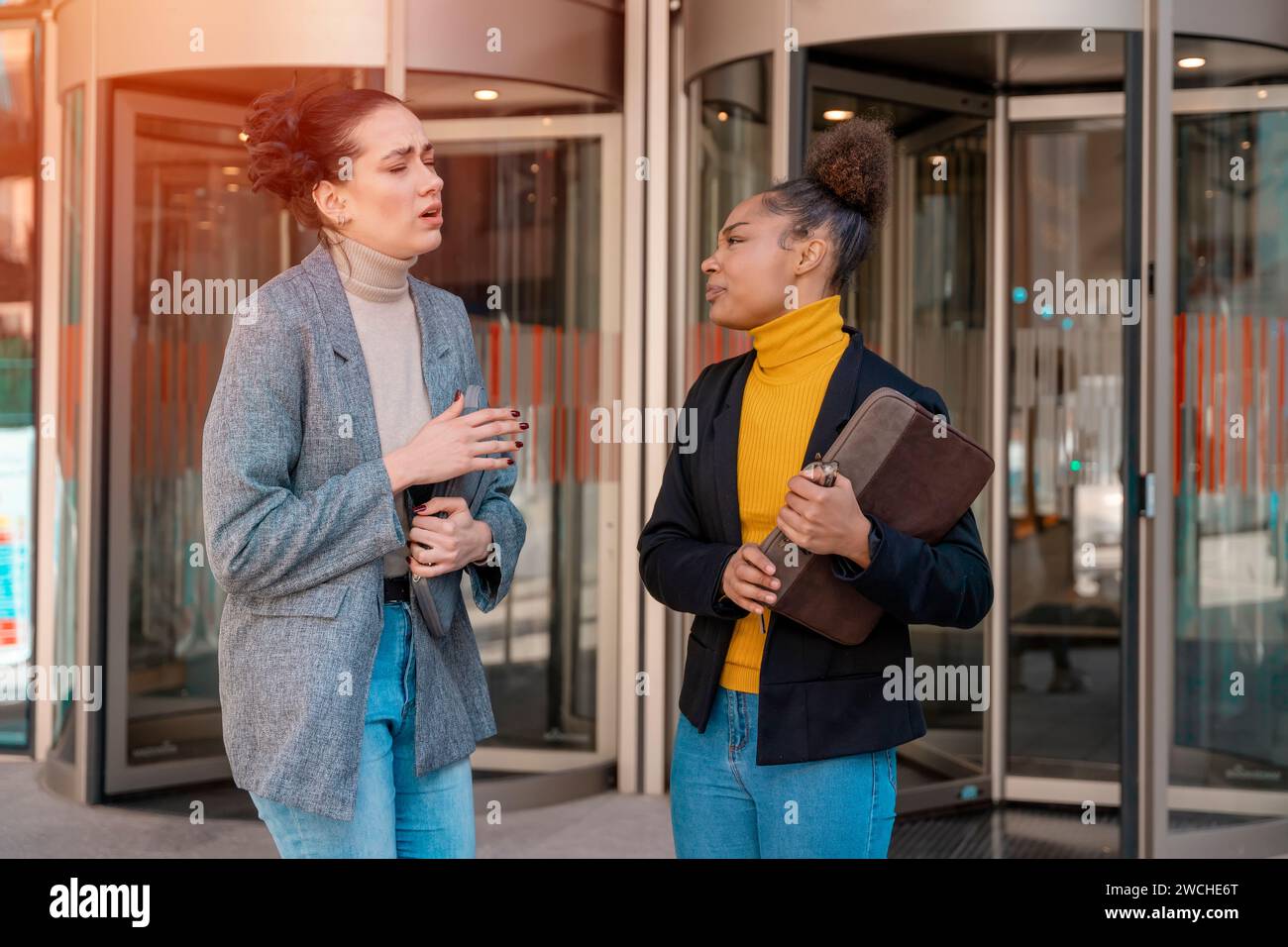 Unhappy two businesswomen wearing office suits with digital tablets ...