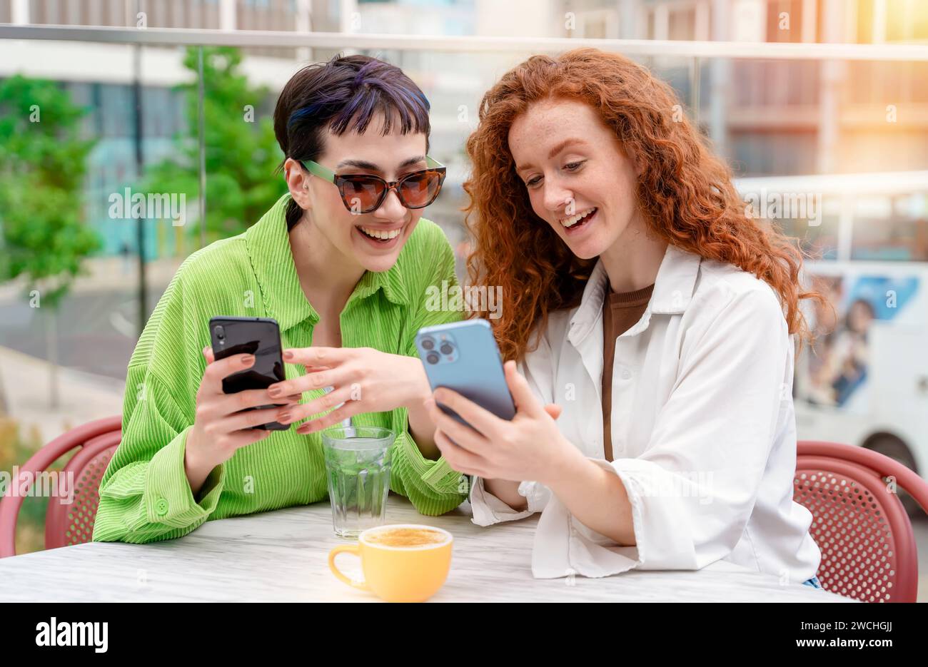 smiling young women having a fun tume together, talking and using ...