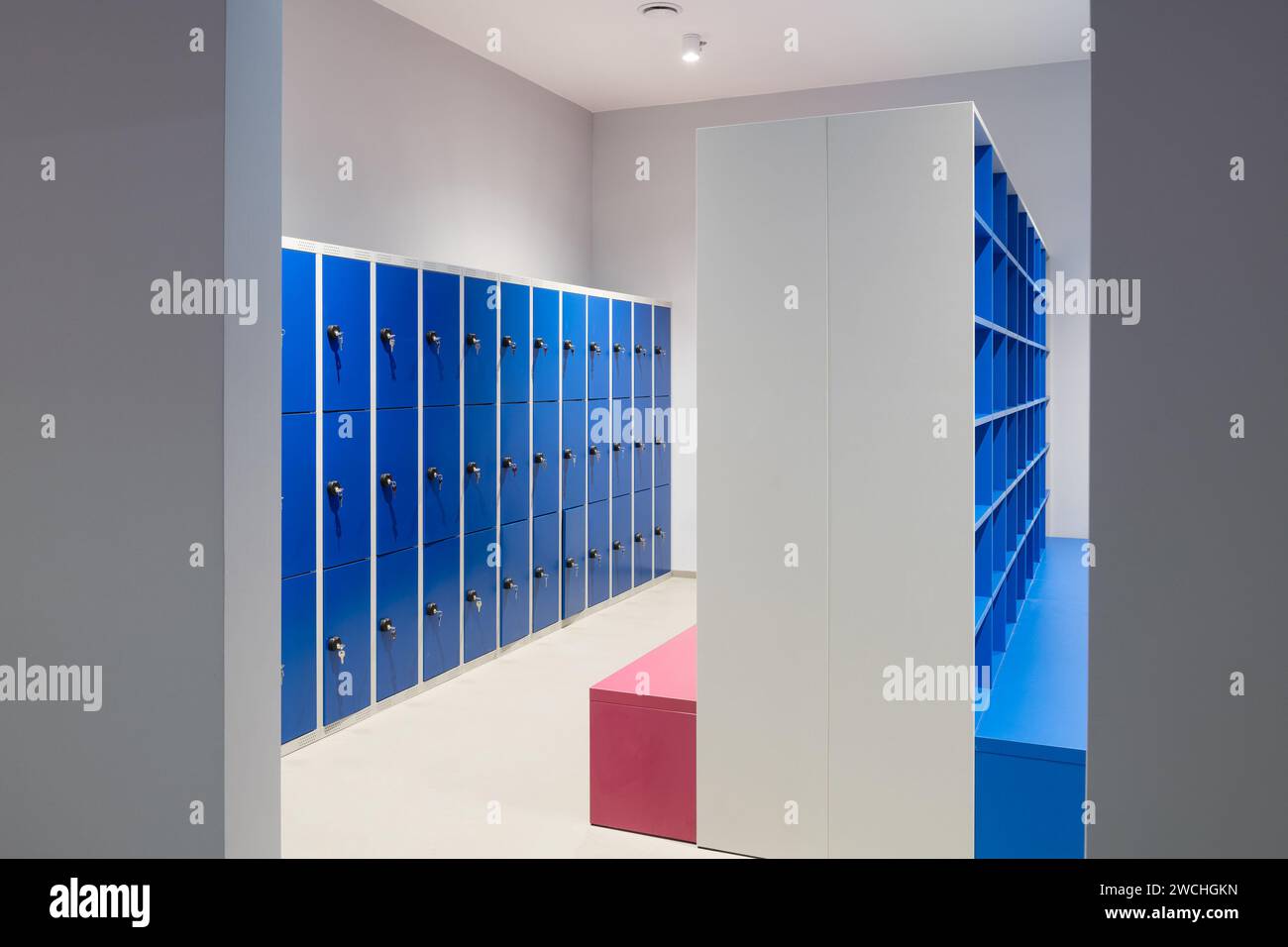 Blue lockers on a wall with key in a lock and cabinet with empty ...